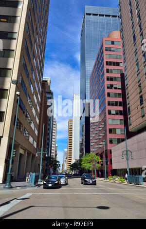 A street scene in a city with tall buildings lining both sides. A group ...