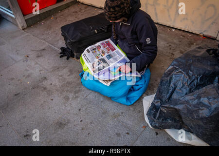 homeless person reading newspaper Stock Photo - Alamy