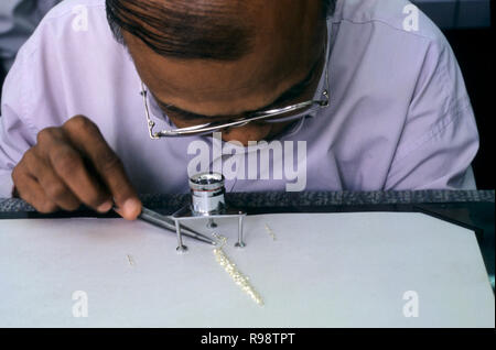 Man sorting grading looking at diamond through magnifying glass Stock ...