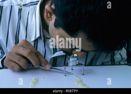 Man sorting grading looking at diamond through magnifying glass Stock ...