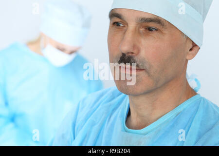 Boss surgeon is examining the operation while medical team are busy of ...