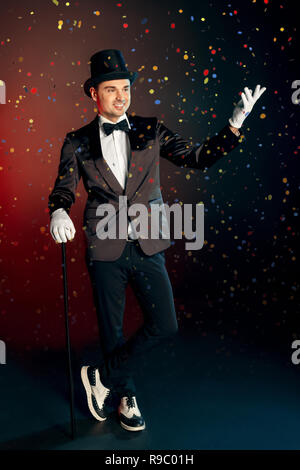 Professional showman wearing suit gloves and top hat standing isolated ...