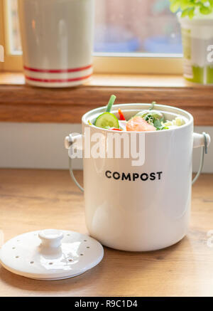 Compost bin on kitchen counter with olive oil bottles in modern home ...