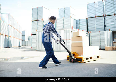 Delivery man pushing stack of packages Stock Photo - Alamy