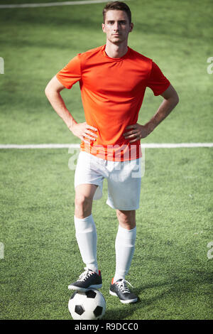 Young soccer player in sportswear with soccer ball. Cheerful little boy ...