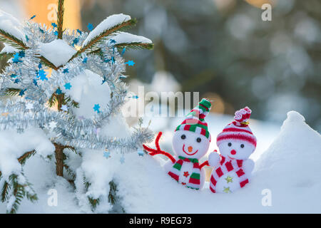 Two small funny toys baby snowman in knitted hats and scarves in deep ...
