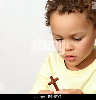 boy praying kissing the cross on white background with people stock ...