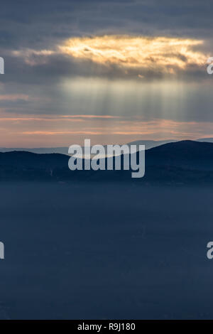 Sunray shines through clouds over the mountains and a sea of fog Stock ...