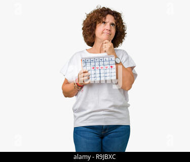 Middle ager senior woman holding menstruation calendar over isolated ...