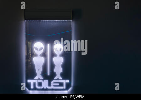 Illuminated alien sign, futuriistic alien toilet sign Stock Photo - Alamy