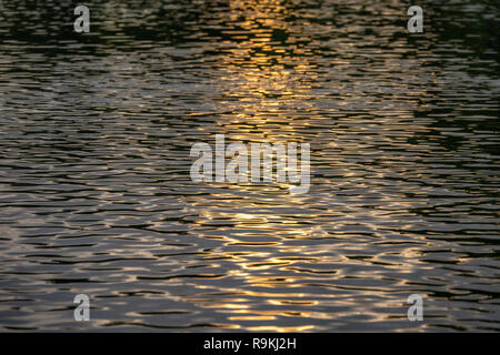 Setting sun reflecting on river water patterns Stock Photo - Alamy
