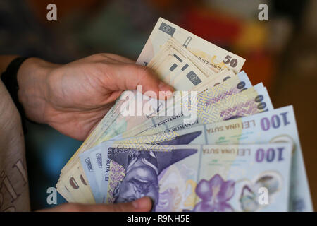 Details with the hands of a young lady counting banknotes of 50 and 100 ...