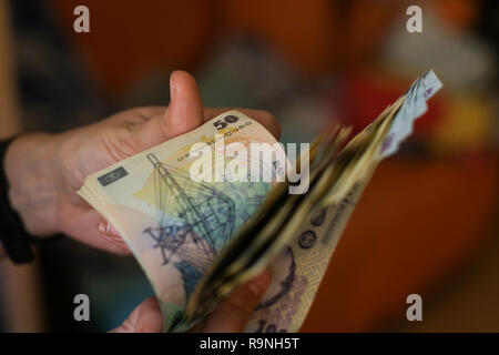 Details with the hands of a young lady counting banknotes of 50 and 100 ...