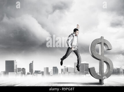 Determined banker man against modern cityscape breaking dollar concrete ...