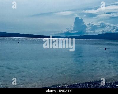 Dramatic and moody view of a calm sea under a gloomy sky background ...