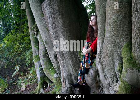 Girl sitting between autumn trees, boulevard Stock Photo - Alamy