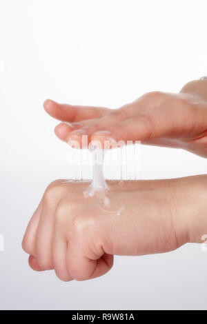 rub a sticky cream on the back of one's hand Stock Photo: 229821792 - Alamy