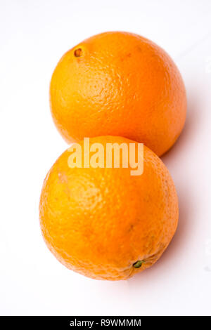 Two whole and unpeeled oranges on the white background Stock Photo - Alamy