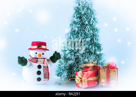 Snowman stand near gift box on white background. Snow flake is falling ...