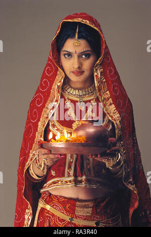 Rural Indian village bride dressed in colourful sari and gold jewelry ...