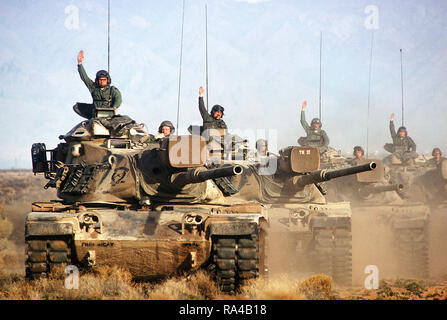 A convoy of M-60 main battle tank moves down a road during a training ...