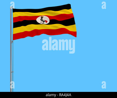 Isolate flag of Uganda on a flagpole fluttering in the wind on a blue ...