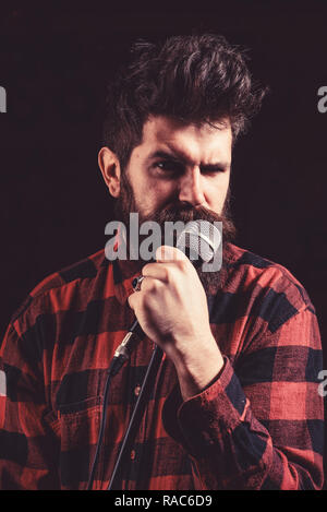 Vocalist concept. Musician with beard and mustache lighted by spotlight ...