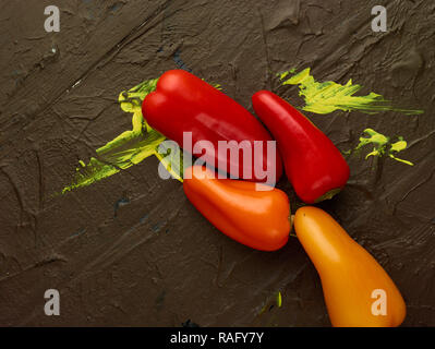Mini sweet capsicum pepper against dark background with yellow flecks ...