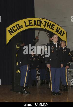 A newly promoted NCO walks through the NCO arch and crossed sabers ...