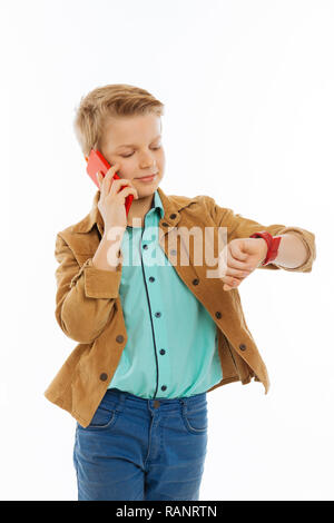 Delighted positive boy looking at his watch Stock Photo - Alamy