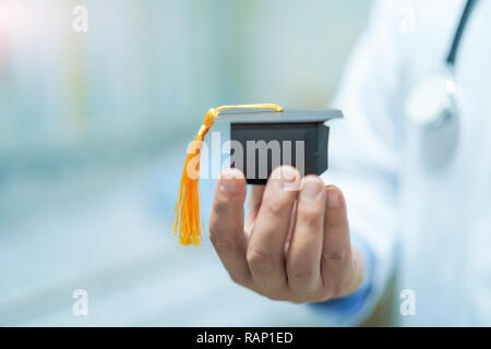 Asian doctor study learn with graduation gap hat in hospital ward ...