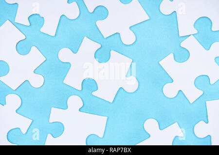 full frame of white puzzles arrangement on blue backdrop Stock Photo ...