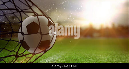 Composite image of football hitting the back of the net Stock Photo - Alamy