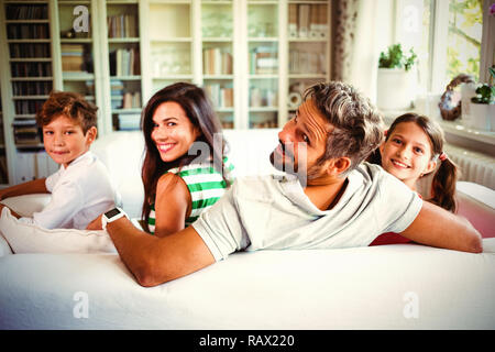 happy family sitting on sofa and reading travel newspaper in living ...