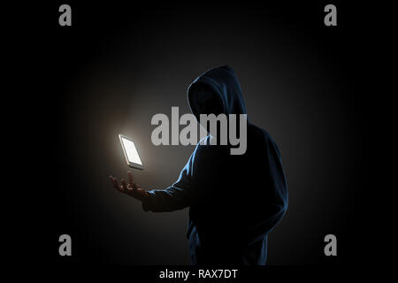 White smartphone floating above of hacker's hand in dark background ...