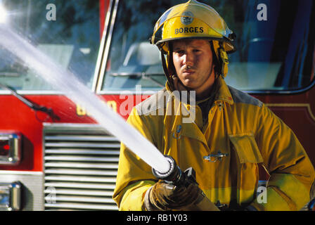 Fireman mans a hose to extinguish a fire, USA 1997 Stock Photo - Alamy