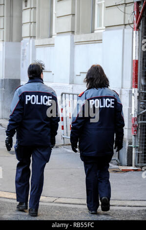 Female Swiss police officer in uniform with equipment, from behind ...