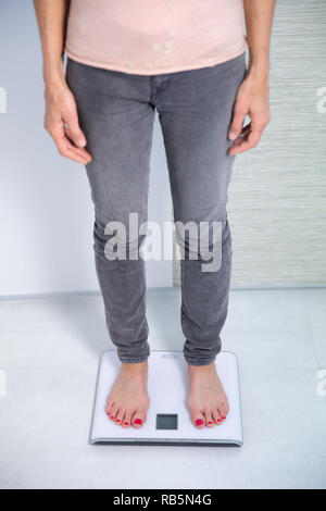 Woman being weighed at the doctor's Stock Photo - Alamy