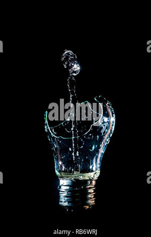 Creative broken light bulb with water fountain on isolated black ...