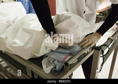 A dead body (corpse) is just arrived in the mortuary chamber in an ...