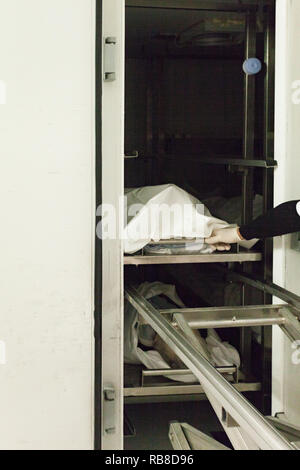 A dead body (corpse) is just arrived in the mortuary chamber in an ...