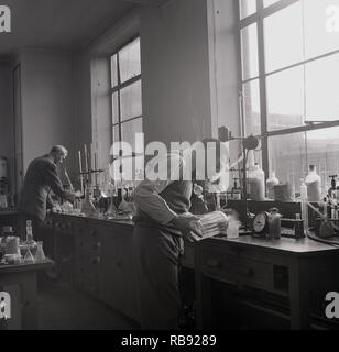1950s, historical, male scientists in a laboratory conducting ...