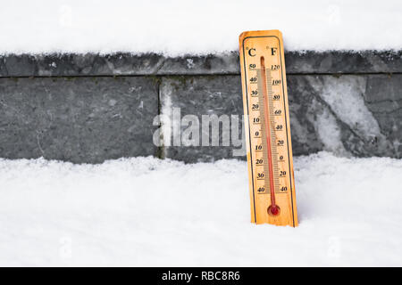 Ice cold thermometer in ice and snow to illustrate global warming, with ...
