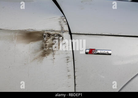 Dented bodywork of a damaged car wing, with steel crushed after a ...