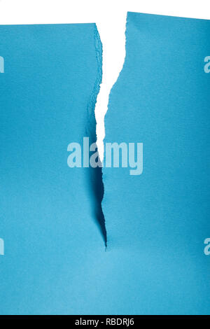 Tear in a piece of blue paper revealing white background underneath ...