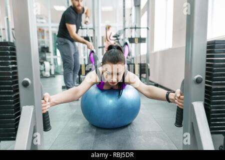 Kinesis technology, kinesitherapy, healthy lifestyle. Young woman doing rehabilitation exercises ...