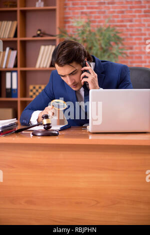 Handsome young man with magnifier and mobile phone on pink background ...