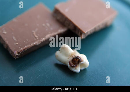 Bad tooth and piece of chocolate. Rotten tooth and chocolate. Unhealthy ...