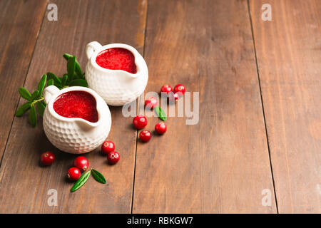 Cranberry sauce in ceramic saucepan with ingredients for cooking. Cranberry sauce for Christmas ...