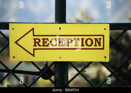 The reception sign with direction arrow on the wall Stock Photo - Alamy